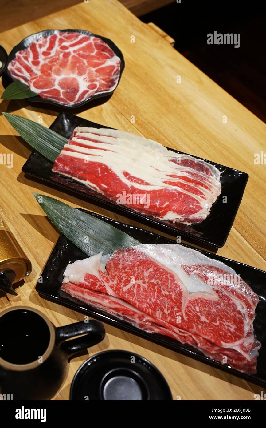 Fresh and raw sliced Japanese Wagyu beef decorated on black ceramic ...