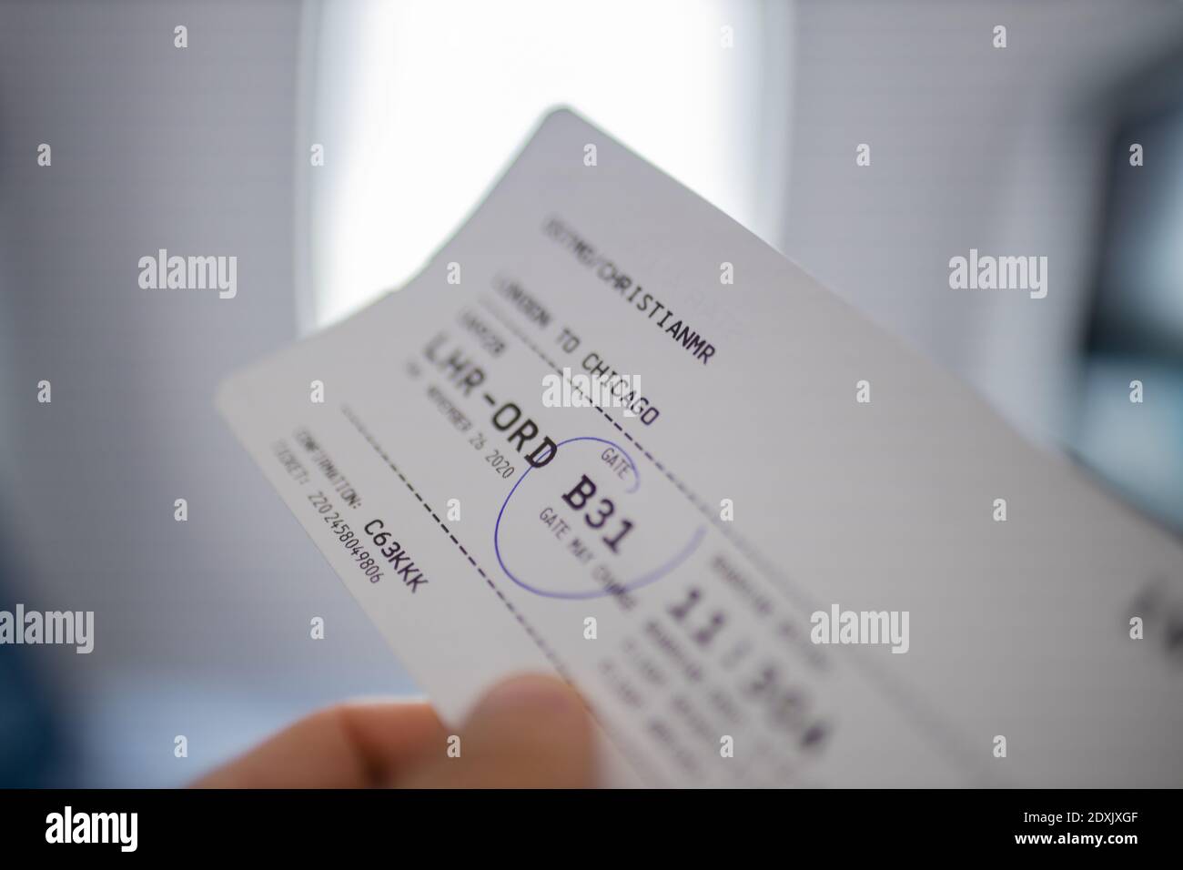 Male hand holding airplane ticket with a window as background Stock ...