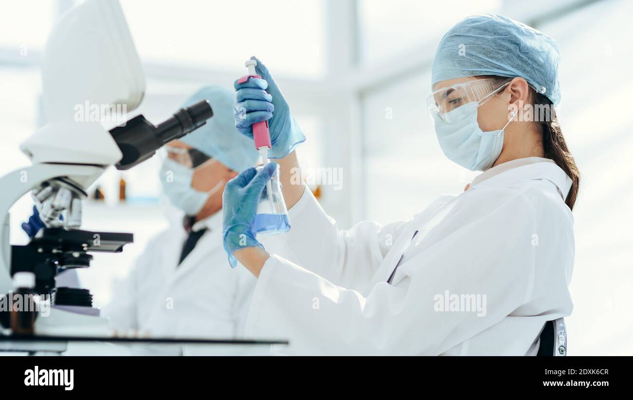 close up. laboratory technician testing liquid in a laboratory flask ...
