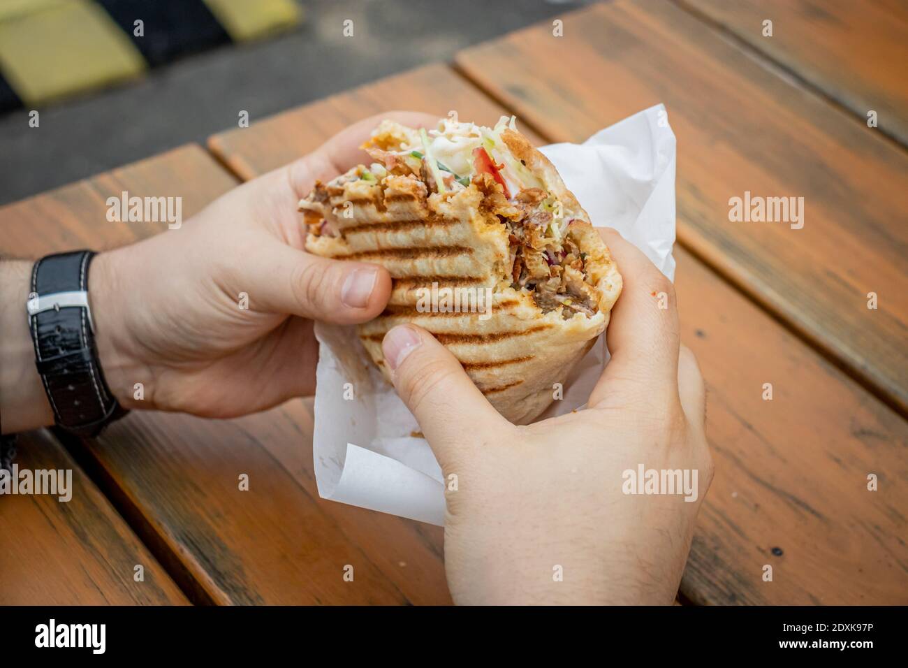 A man eats Doner Kebab at a local street food stall Stock Photo - Alamy