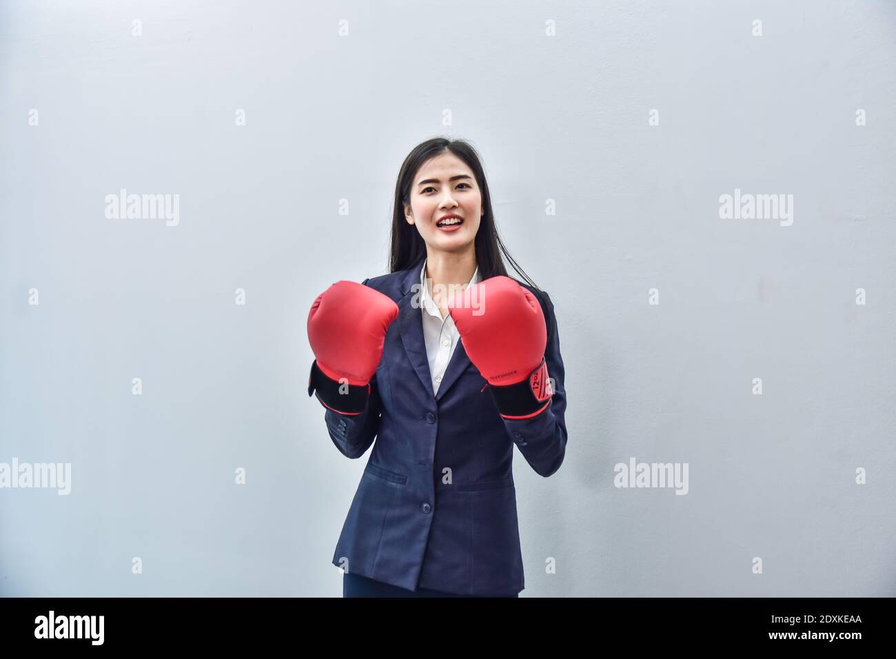Businesswomen Office worker wearing boxing gloves standing on white ...