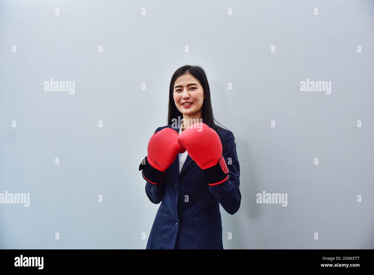 Businesswomen Office worker wearing boxing gloves standing on white ...