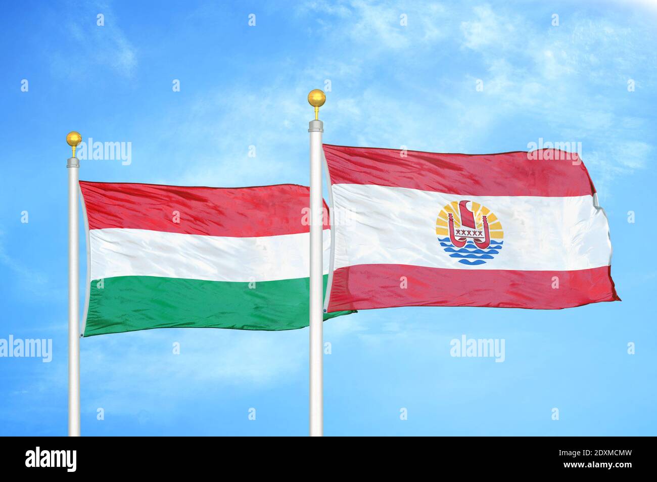 Hungary and French Polynesia two flags on flagpoles and blue cloudy sky ...