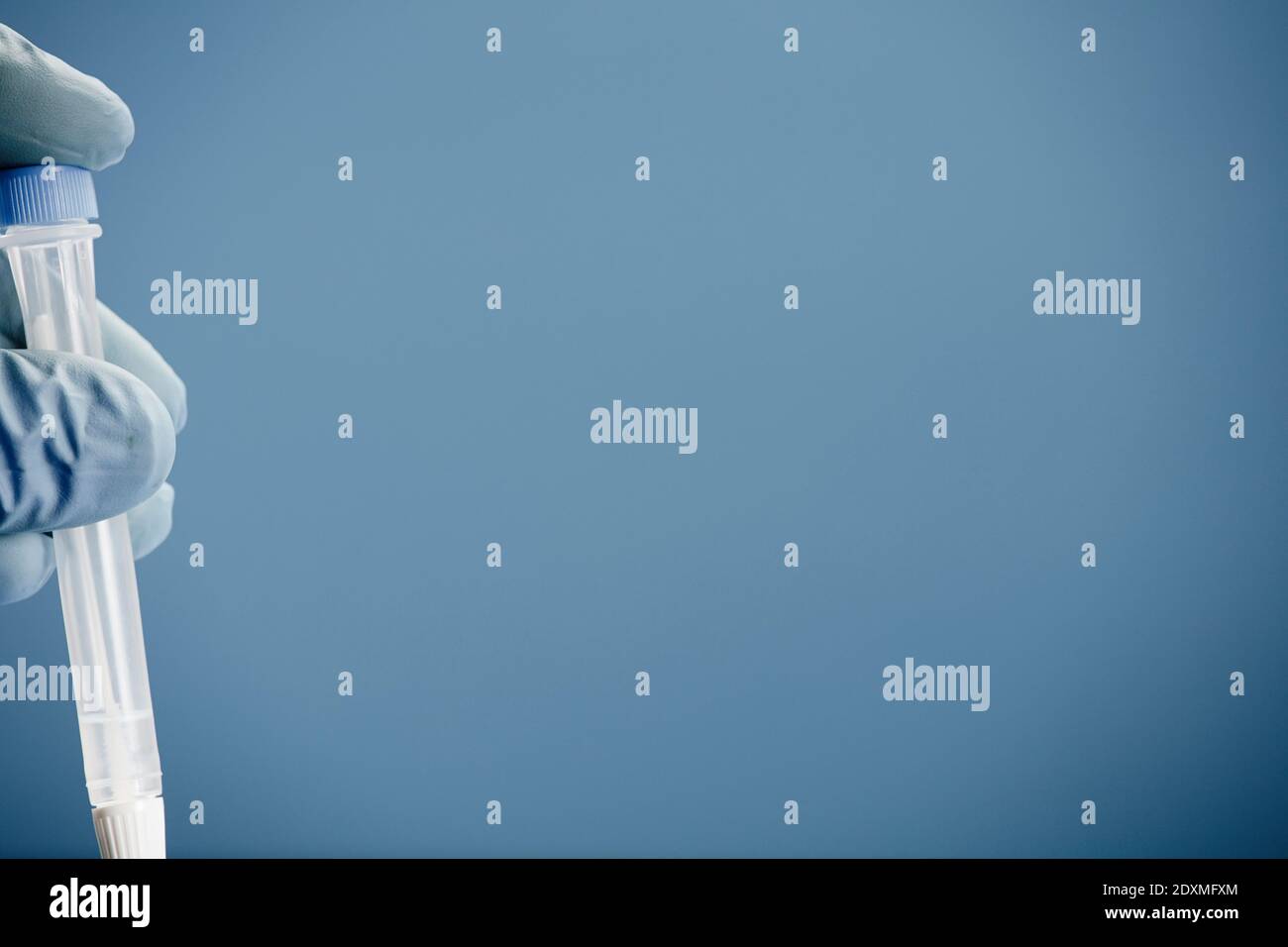 Laboratory scientist with vial and swab indoors performing a rapid ...