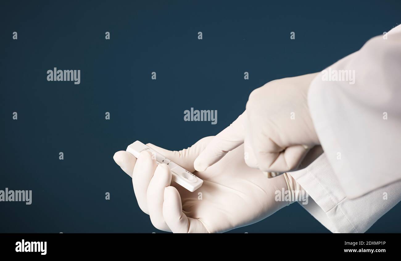 Laboratory scientist with vial and swab indoors performing a rapid ...