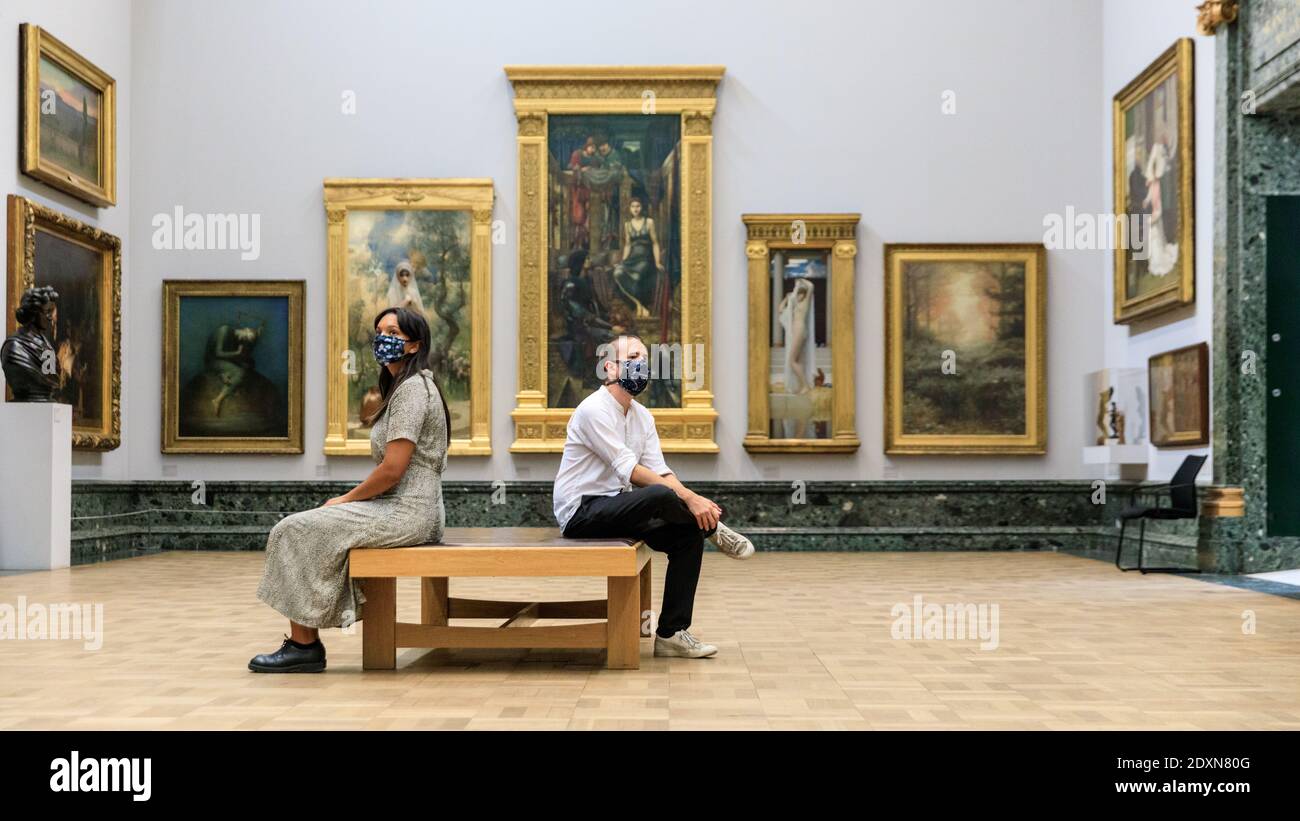 London, UK, 24th July 2020. Two assistants sit in the Pre-Raphaelite ...