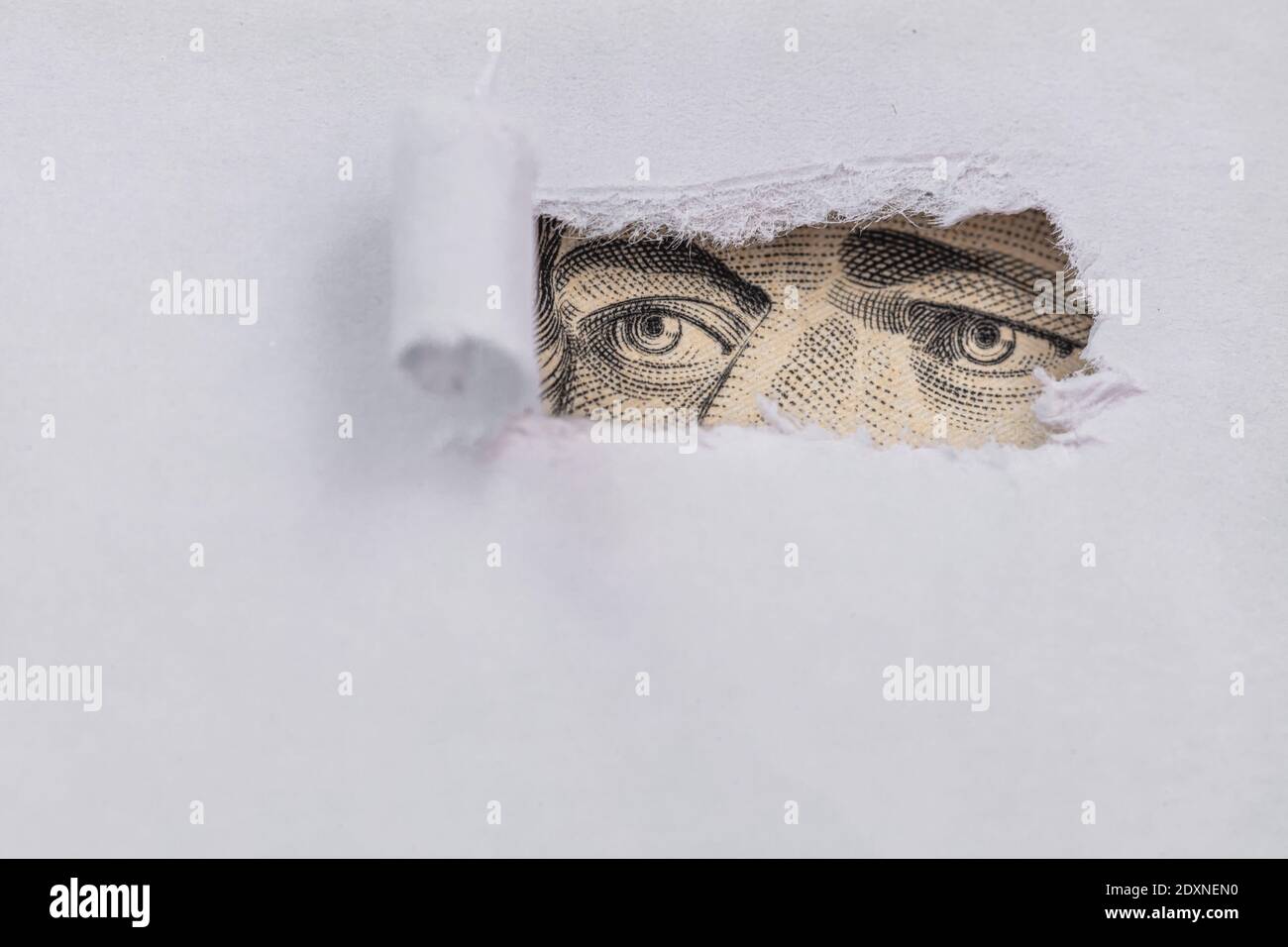 Alexander Hamilton macro peeking through torn white paper Stock Photo ...
