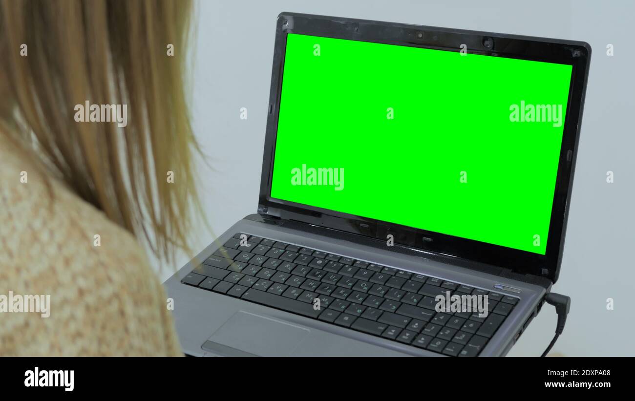 Woman using laptop with green screen Stock Photo - Alamy