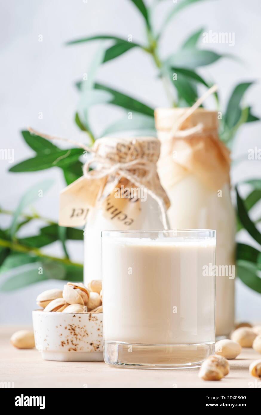 Vegan Pistachio nut milk in bottles, closeup, beige table background ...