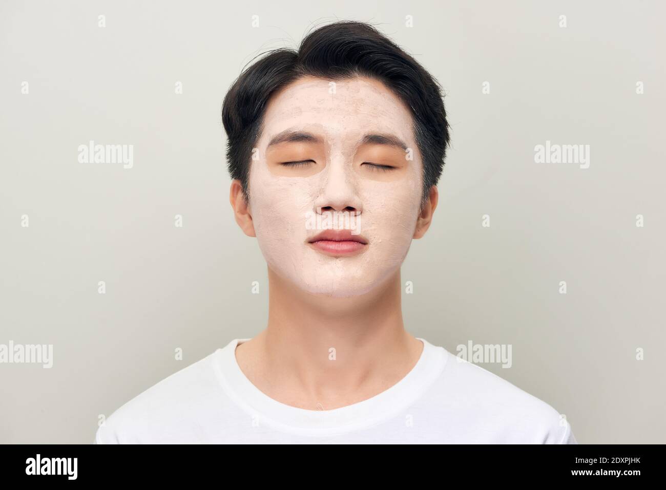 Front portrait of a white male wearing a mud mask beauty treatment ...