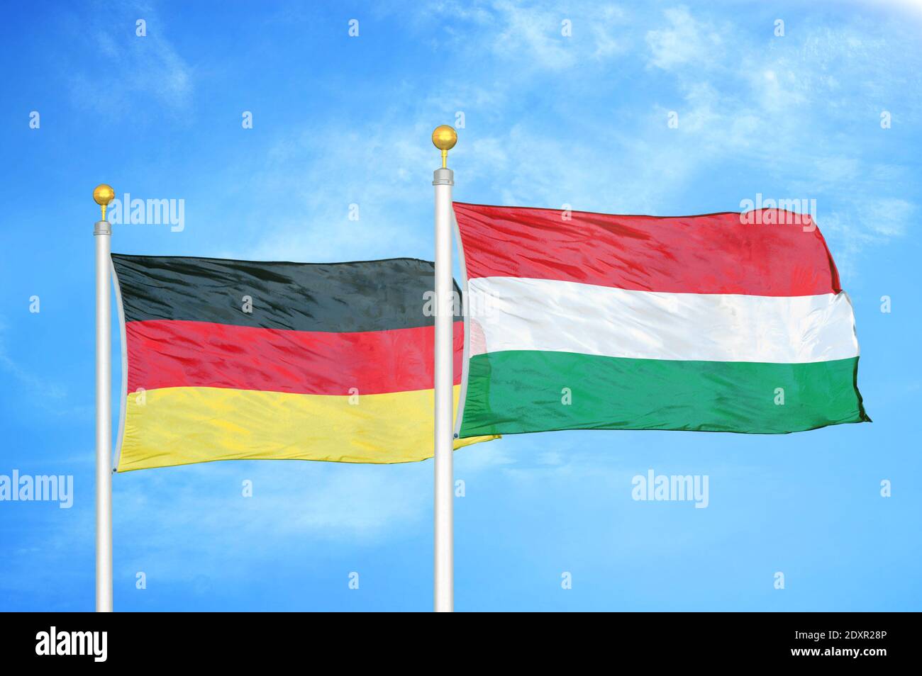 Germany and Hungary two flags on flagpoles and blue cloudy sky Stock ...