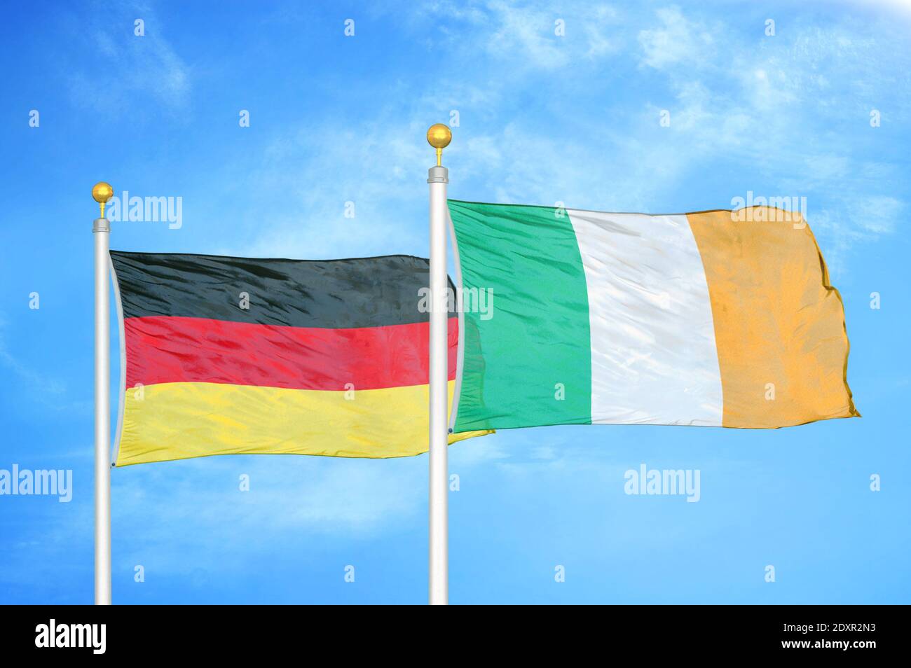 Germany and Ireland two flags on flagpoles and blue cloudy sky Stock ...