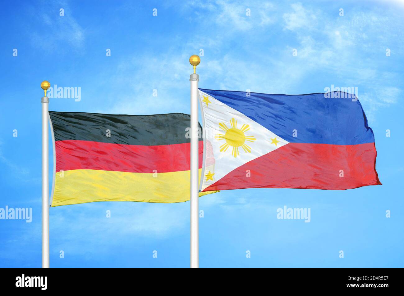 Germany and Philippines two flags on flagpoles and blue cloudy sky ...