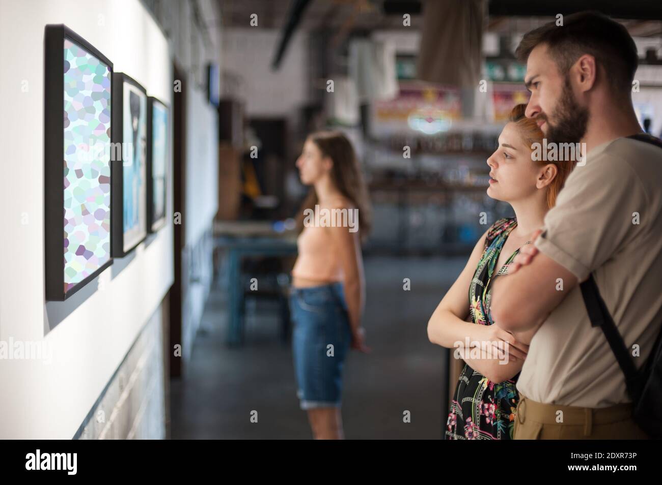 Group of friends in modern art exhibition gallery hall contemplating ...