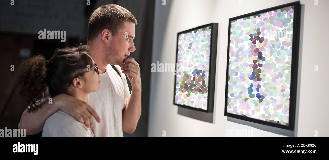 Young couple in modern art exhibition gallery hall contemplating ...