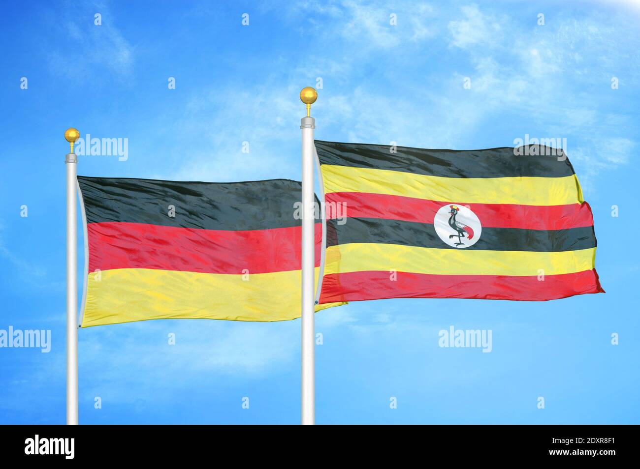 Germany and Uganda two flags on flagpoles and blue cloudy sky Stock ...