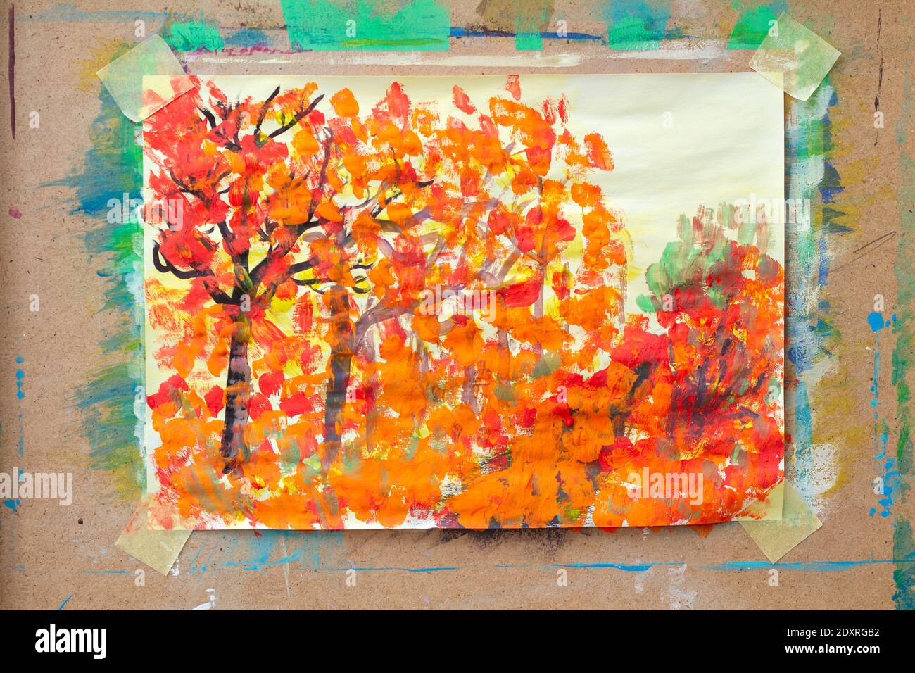 Painting by a young artist depicting autumn trees, attached to an easel ...