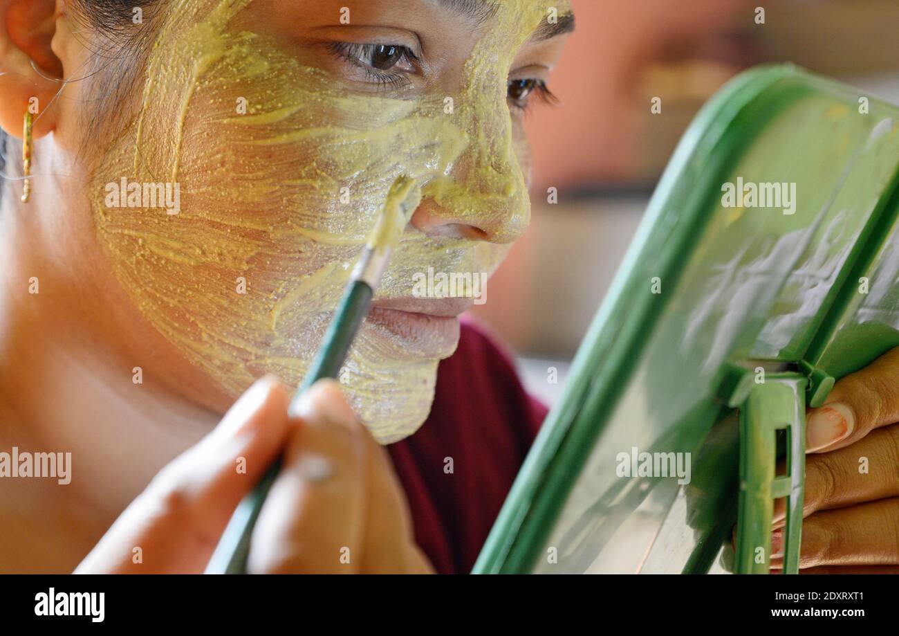 Woman applying with brush clay mud mask to her face Stock Photo - Alamy
