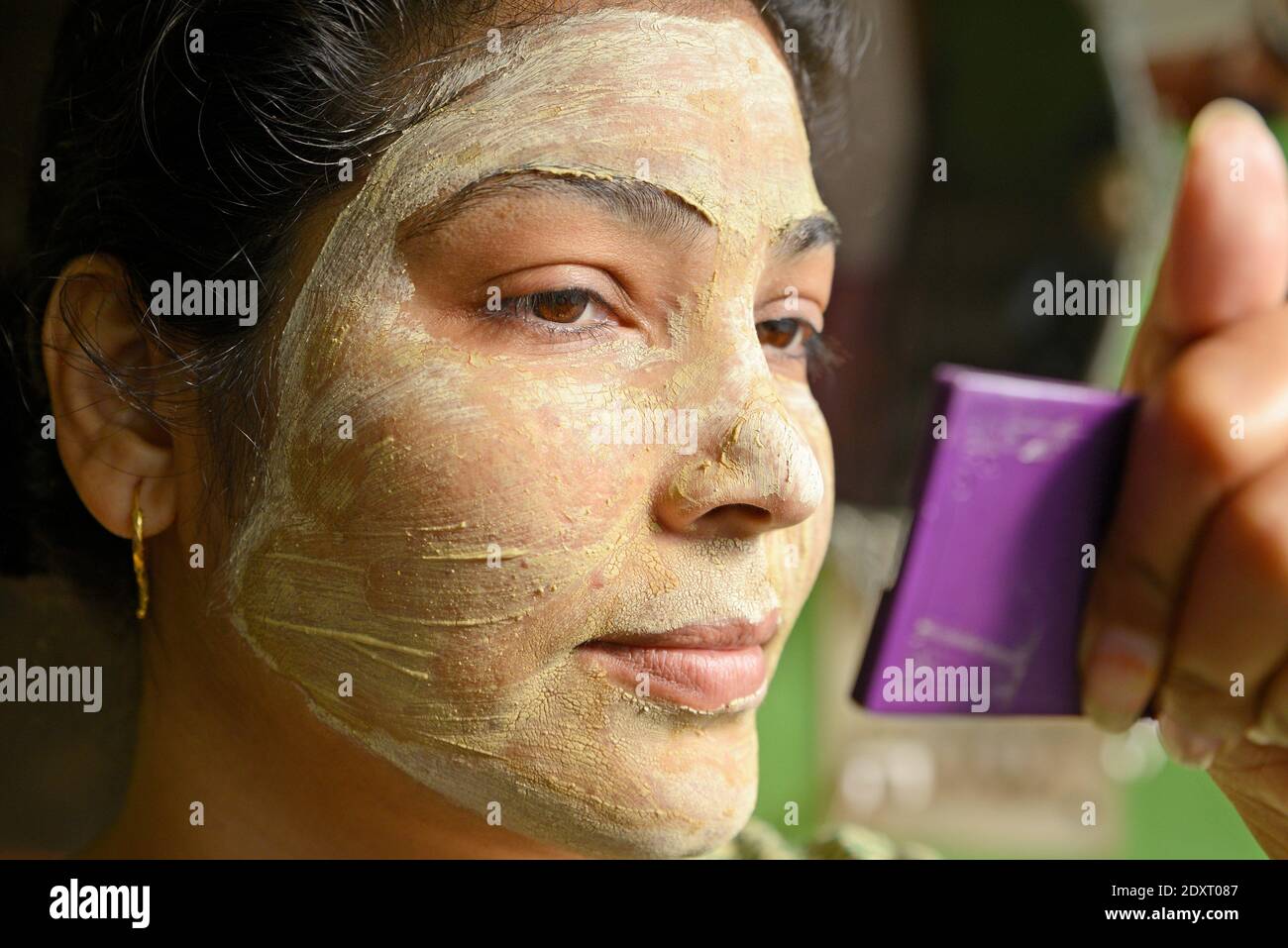 Portrait of woman putting face mask Stock Photo - Alamy