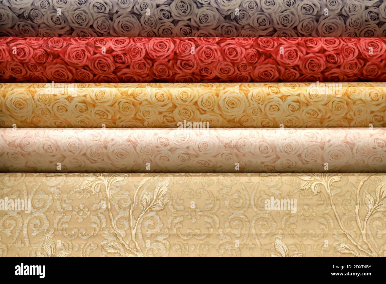 Rolled up rolls of vinyl wallpaper. Different textures and colors, as ...