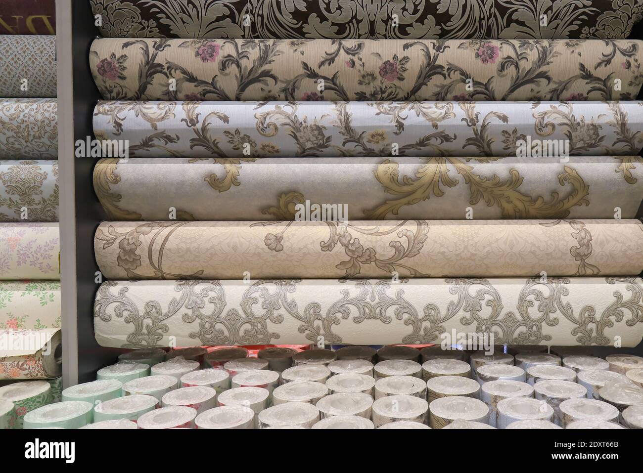 Rolled up rolls of vinyl wallpaper. Different textures and colors, as ...