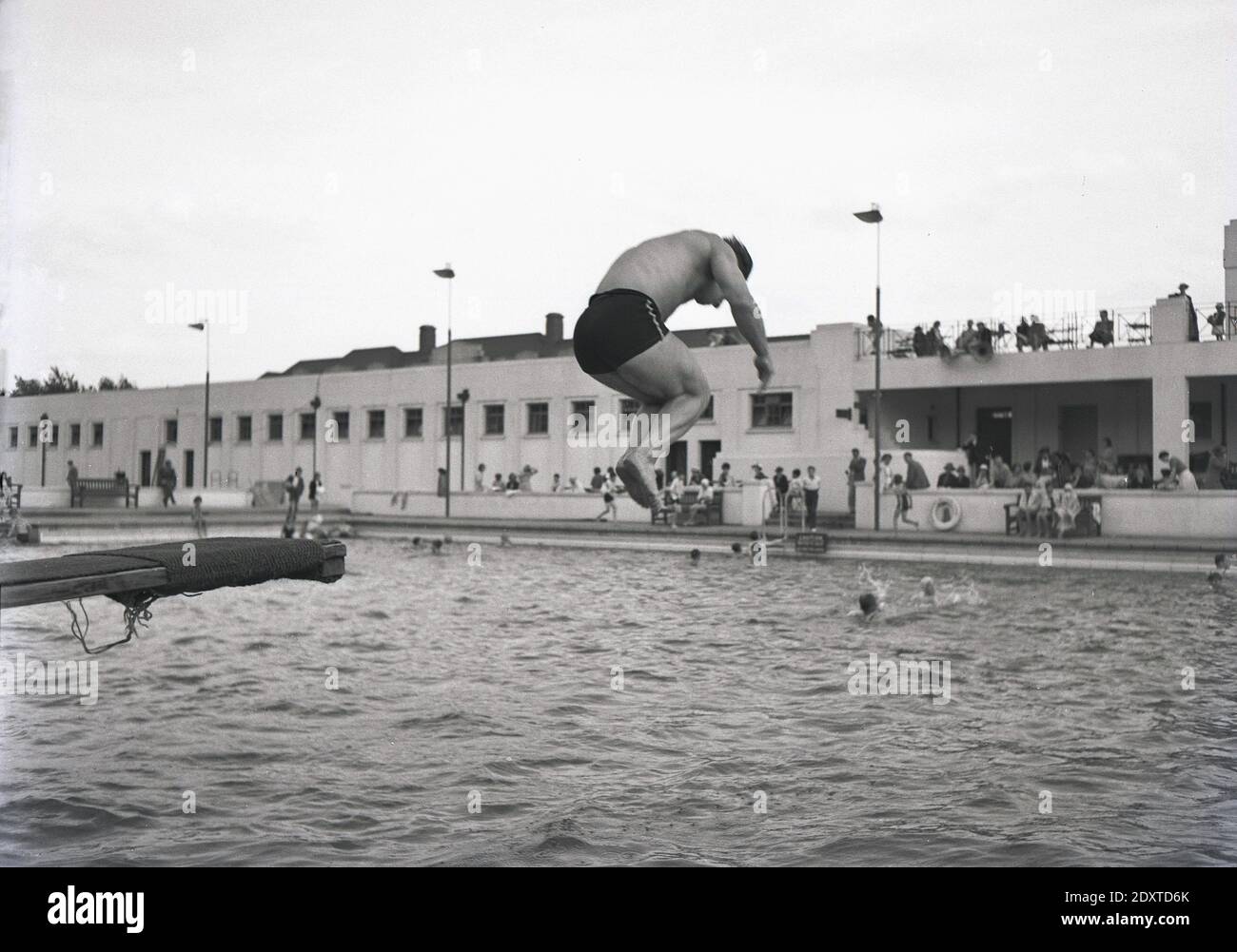 1950s, historical, a male diver leaping from a diving board about to do ...