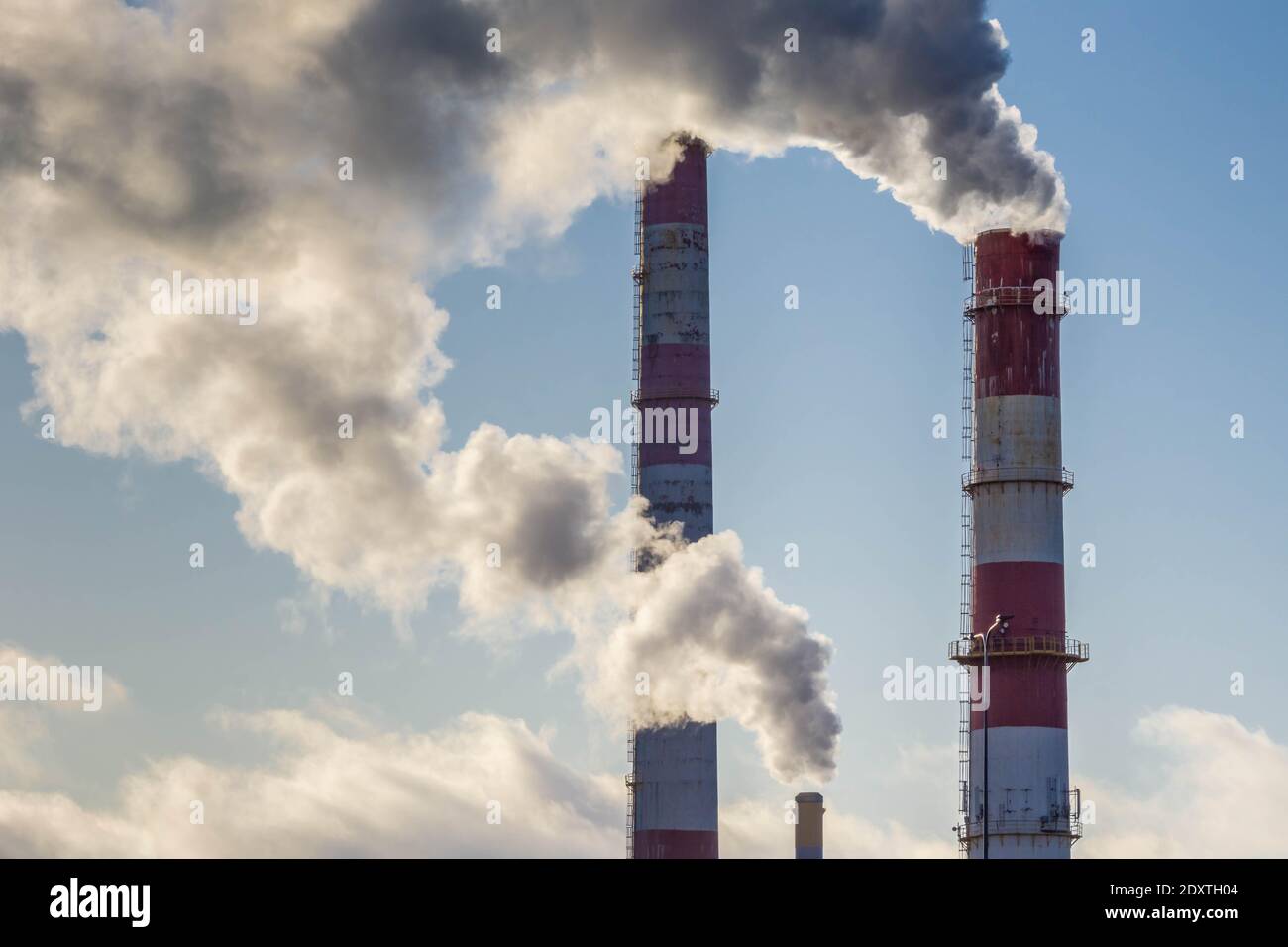 Thick smoke coming from three factory chimneys. Factory pipes with ...