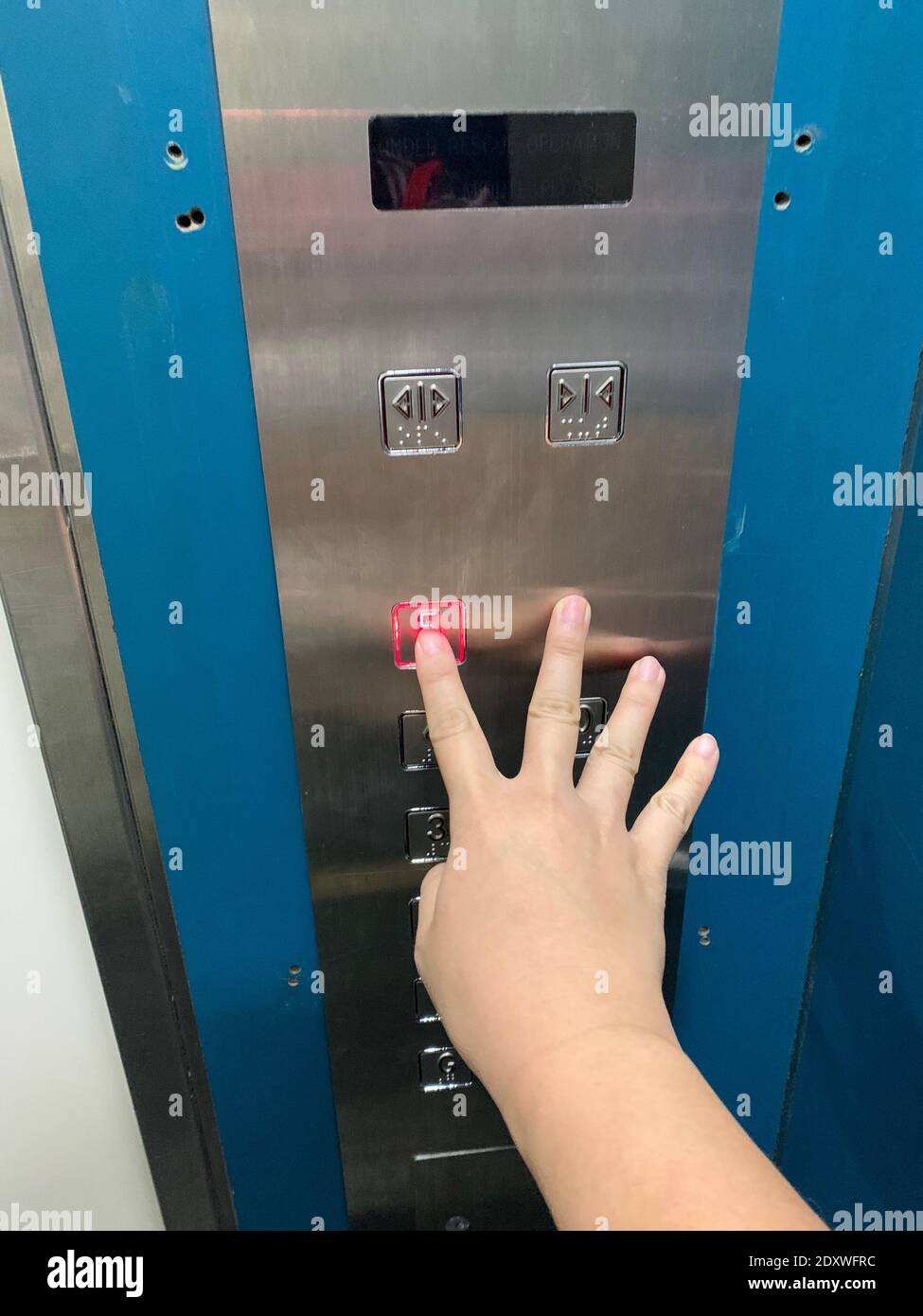 Woman pushing elevator button hi-res stock photography and images - Alamy
