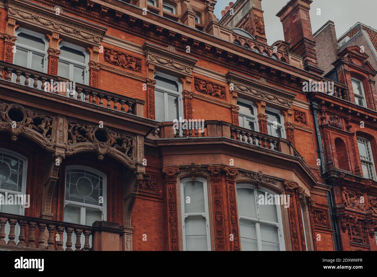 Traditional red brick apartment block with balconies in Mayfair, London ...