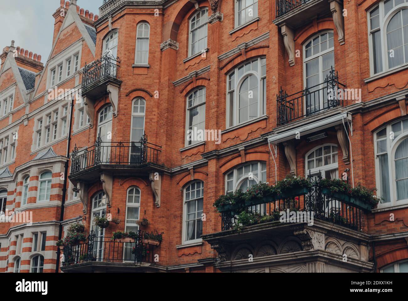 Traditional red brick apartment block with balconies in Mayfair, London ...