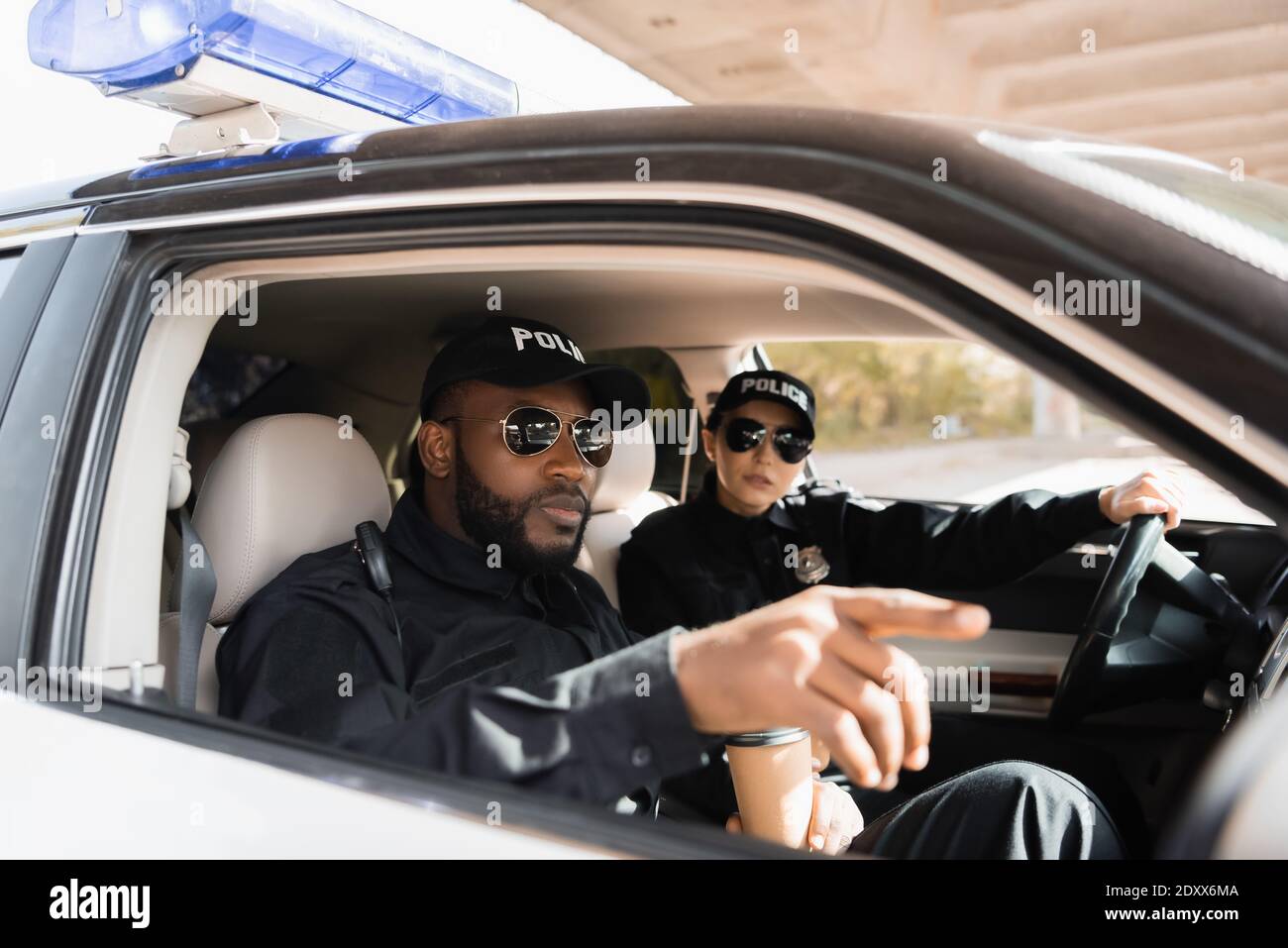 african american police officer pointing with finger near colleague in ...
