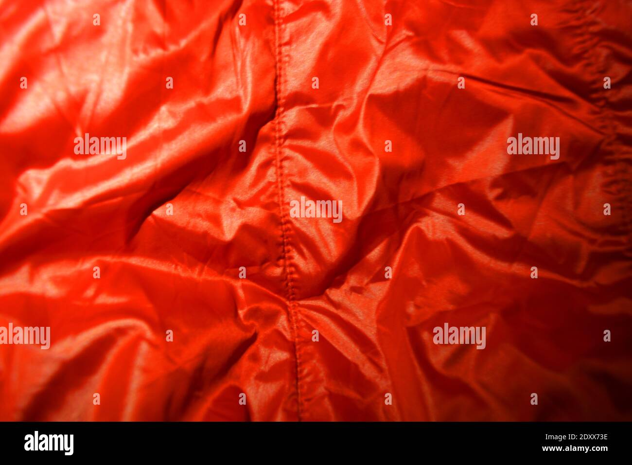 Bright red crumpled, crumpled fabric, fabric background, glossy sheen ...