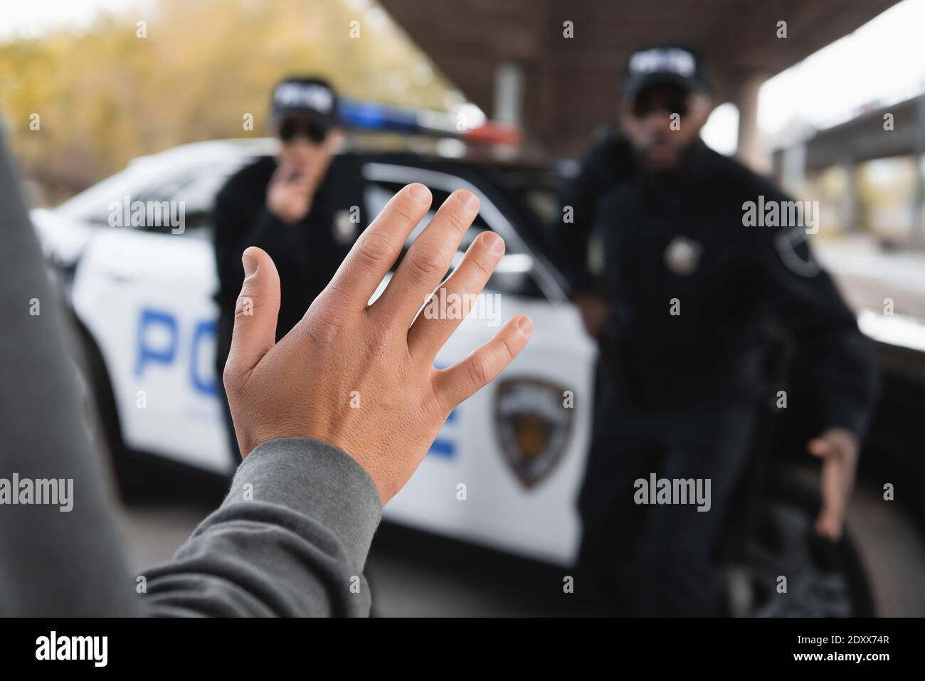 offender showing hand with blurred multicultural police officers on ...