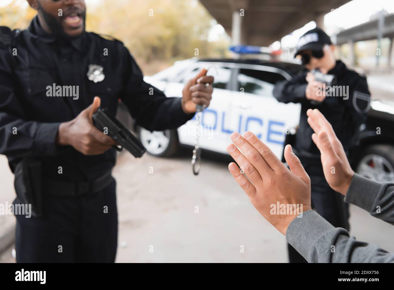 offender showing hands while multicultural police officers holding ...