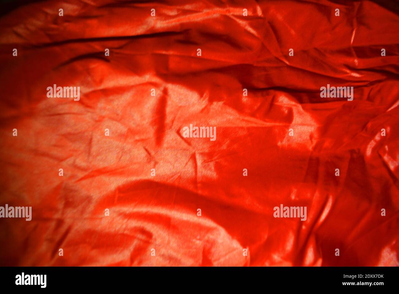 Bright red crumpled, crumpled fabric, fabric background, glossy sheen ...