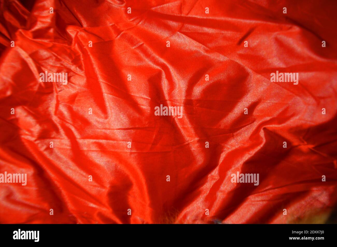 Bright red crumpled, crumpled fabric, fabric background, glossy sheen ...