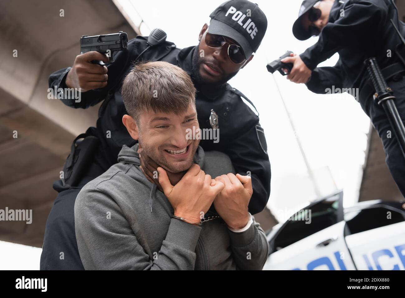 low angle view of african american policeman choking offender while ...