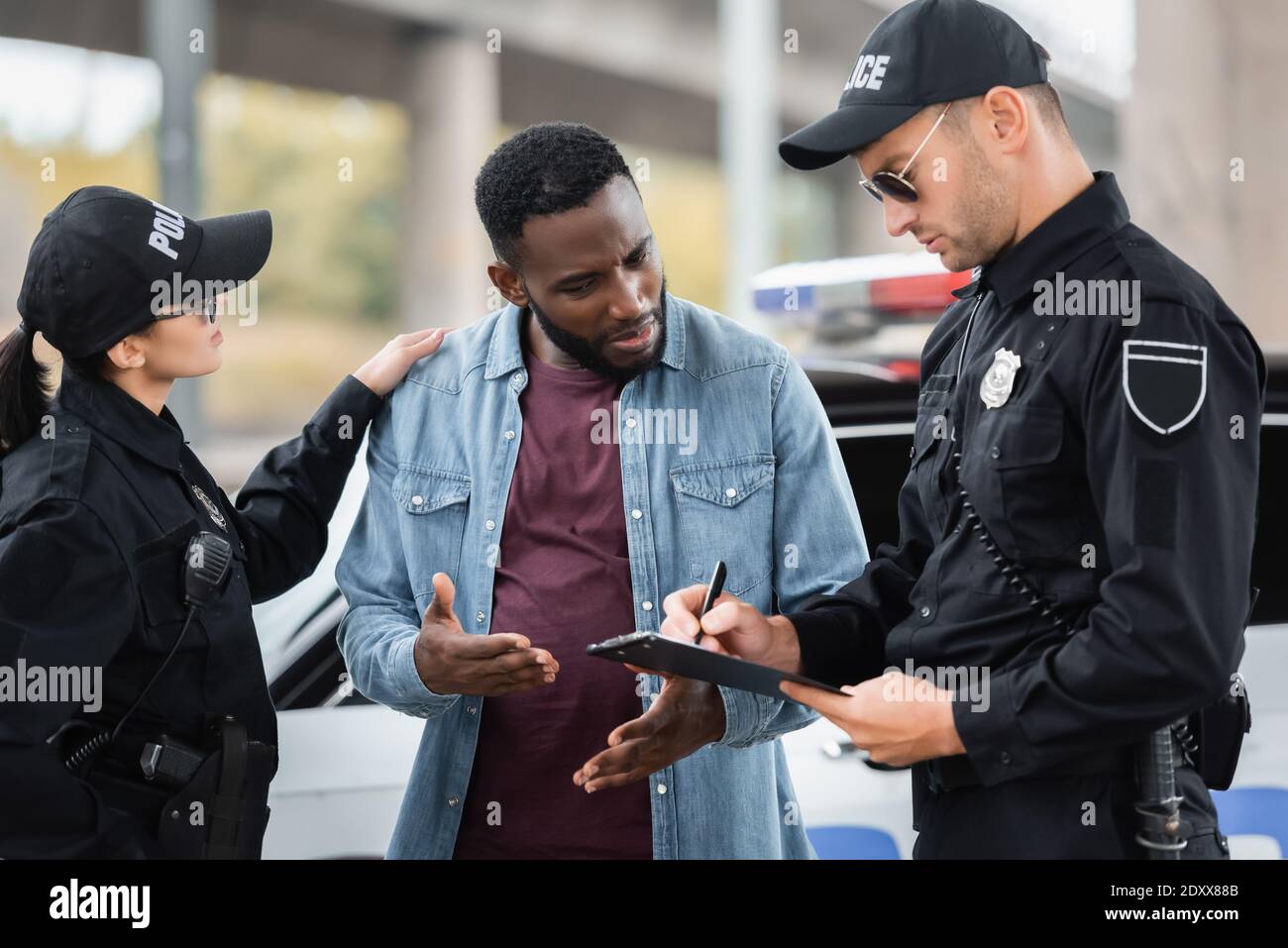 policewoman calming african american victim talking to policeman with ...