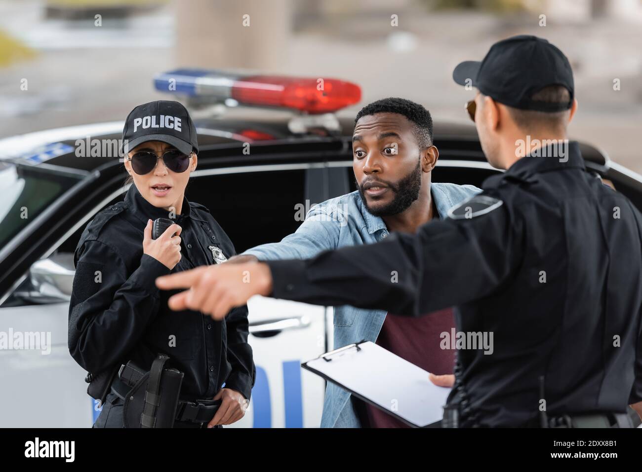 shocked african american victim looking away near police officers on ...