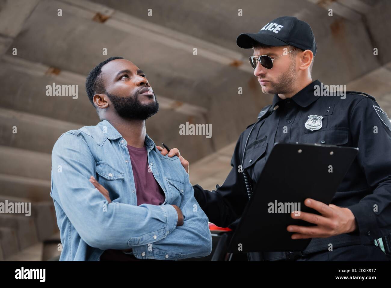 Police officer calming african american victim while holding clipboard ...