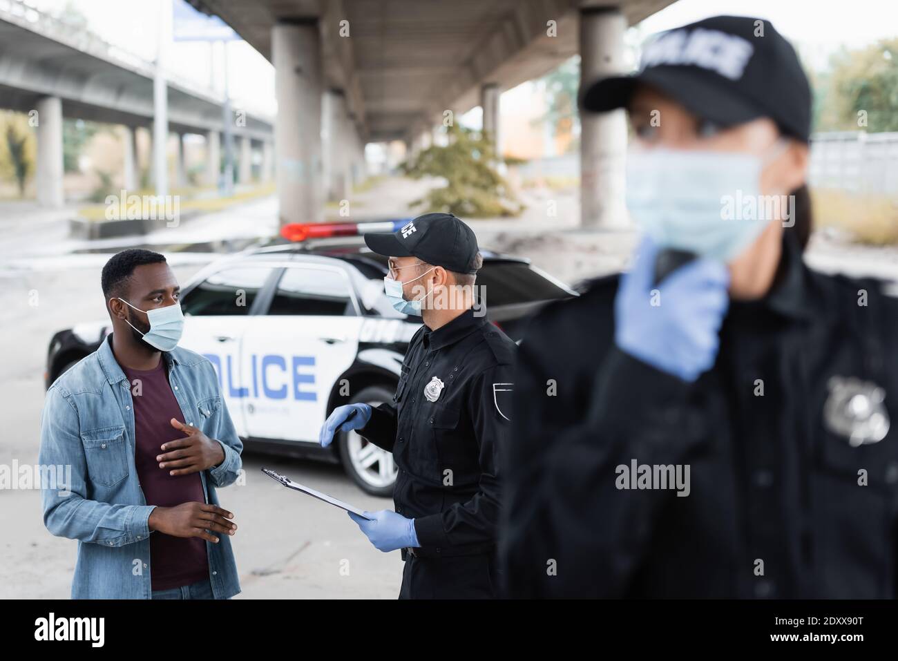 African american victim in medical mask standing near police officer ...