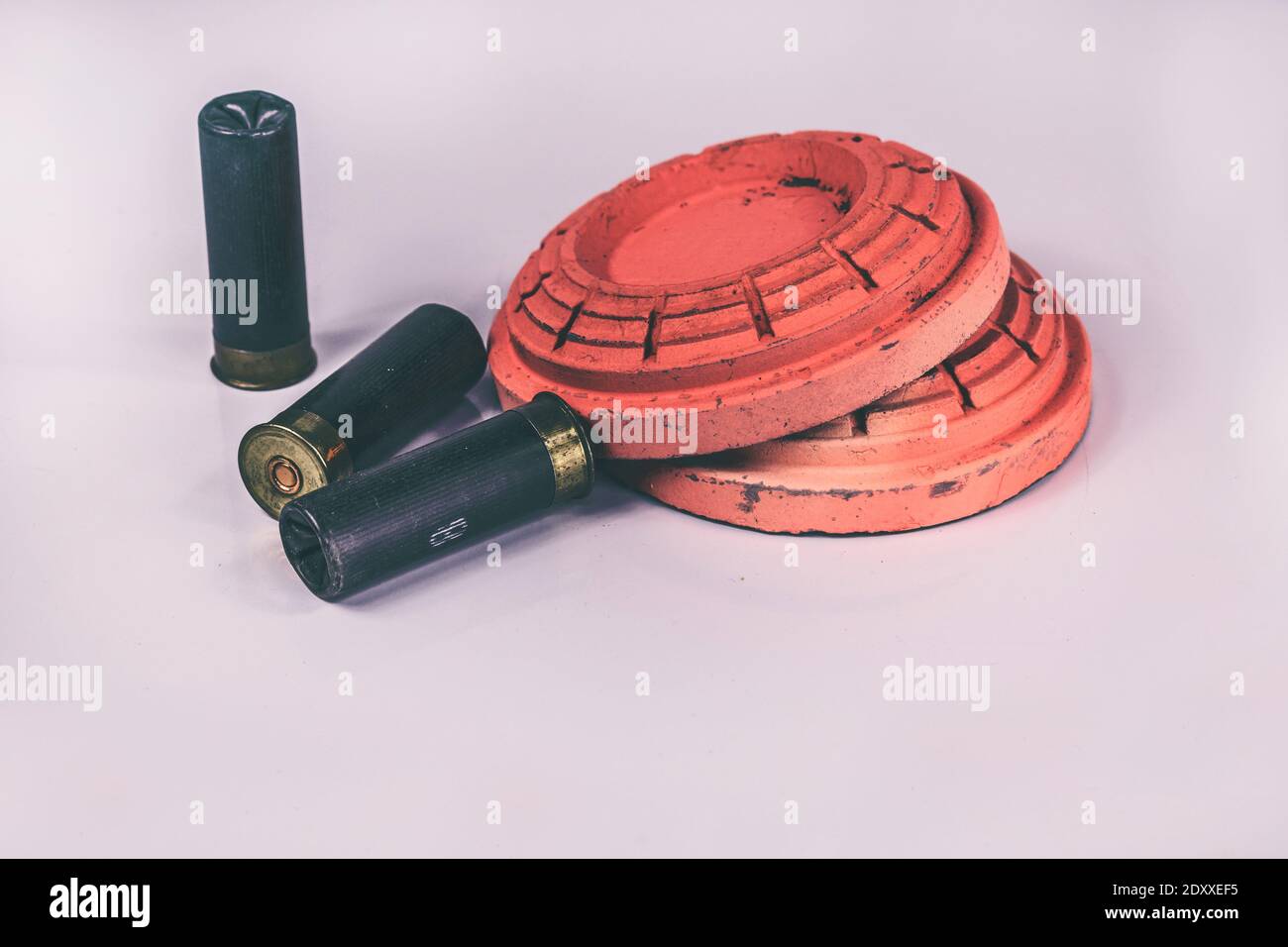 A pair of orange skeet and trap shooting clay targets with shotgun ...