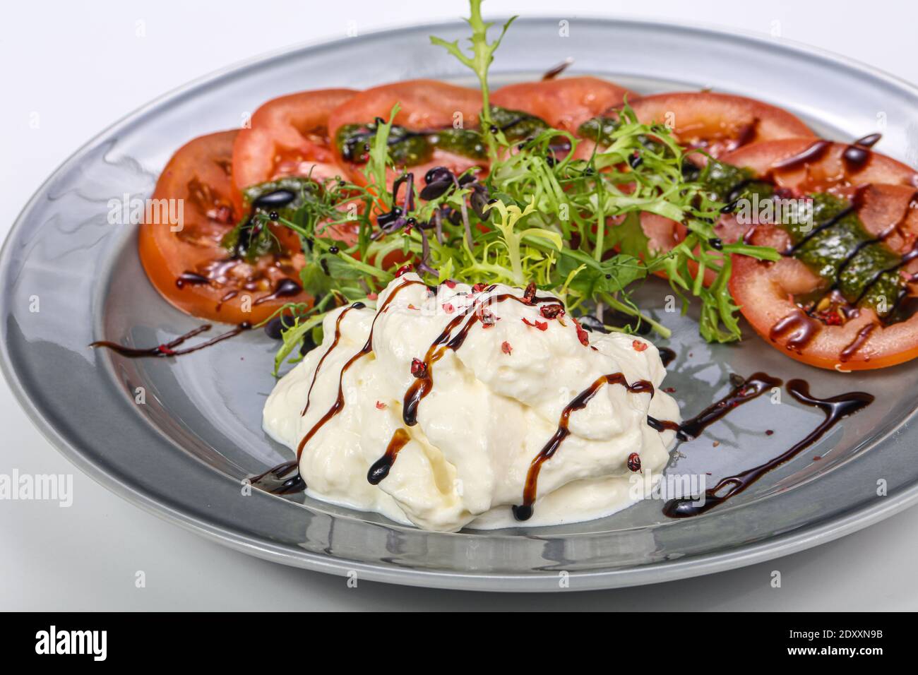 Strachatella cheese with tomato, balsamico and rucola Stock Photo - Alamy