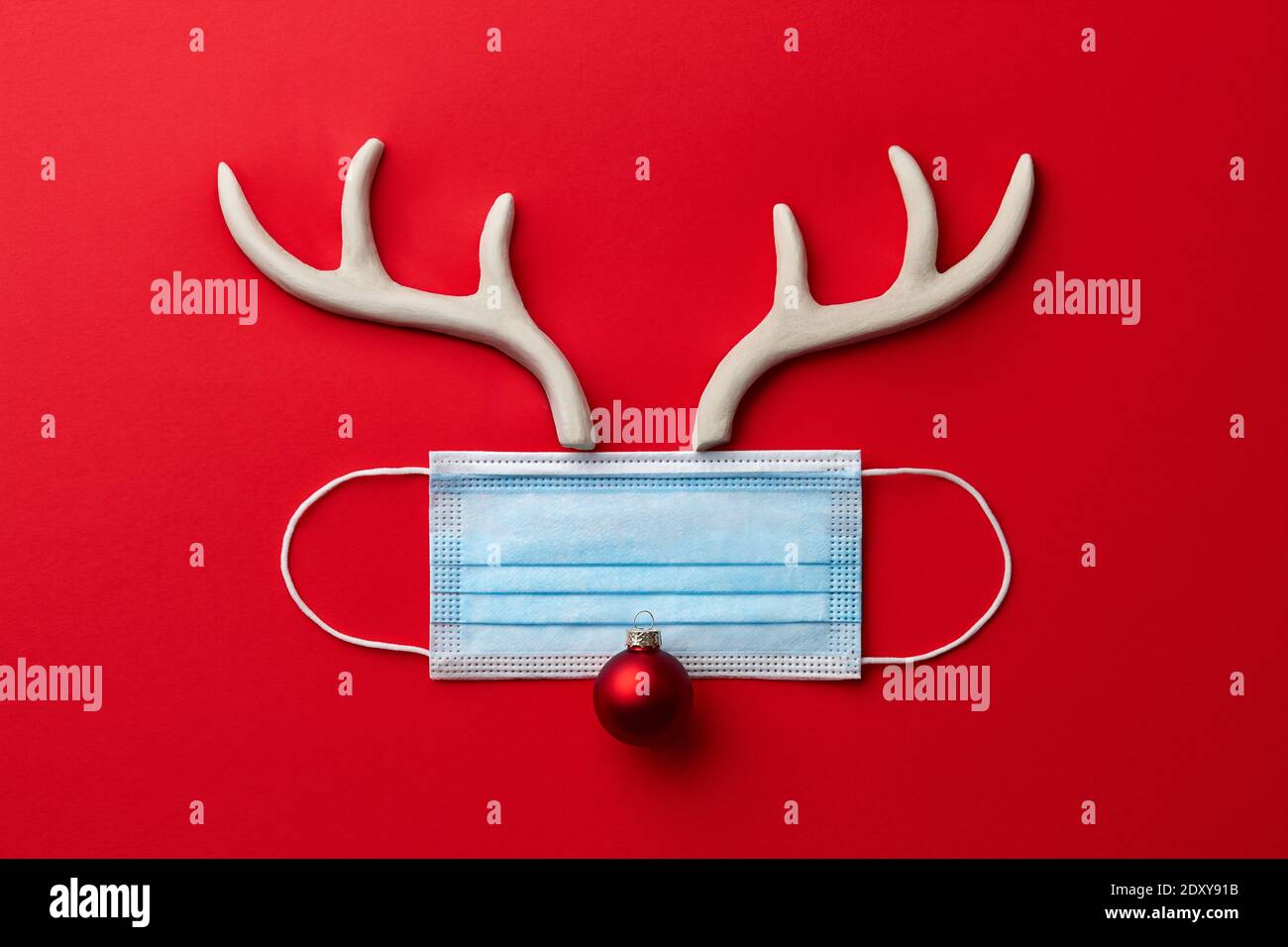 Christmas reindeer made from face mask, antlers and decorations on red ...
