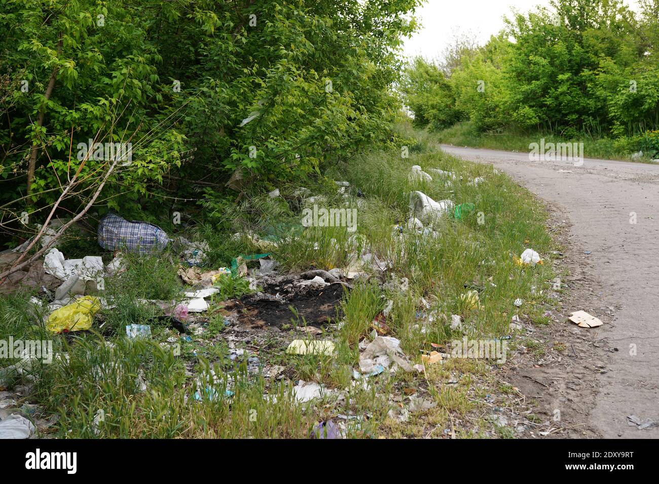 Heaps of trash on the road. Road and footpath full of rubbish / Dirty ...