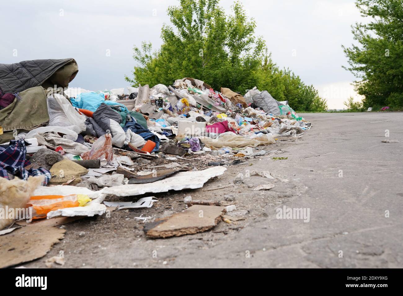 Heaps of trash on the road. Road and footpath full of rubbish / Dirty ...