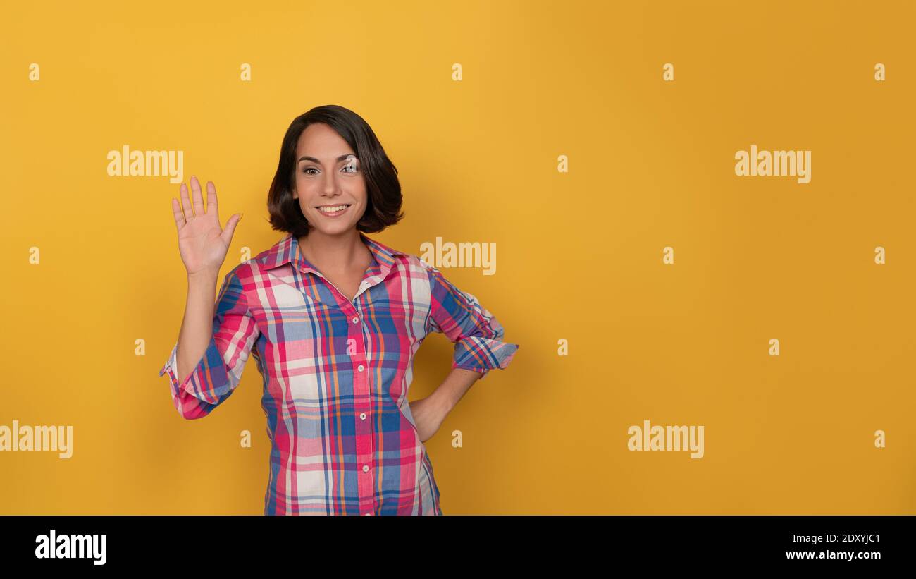 Gesturing HI or saying good by young pretty woman posing on camera ...