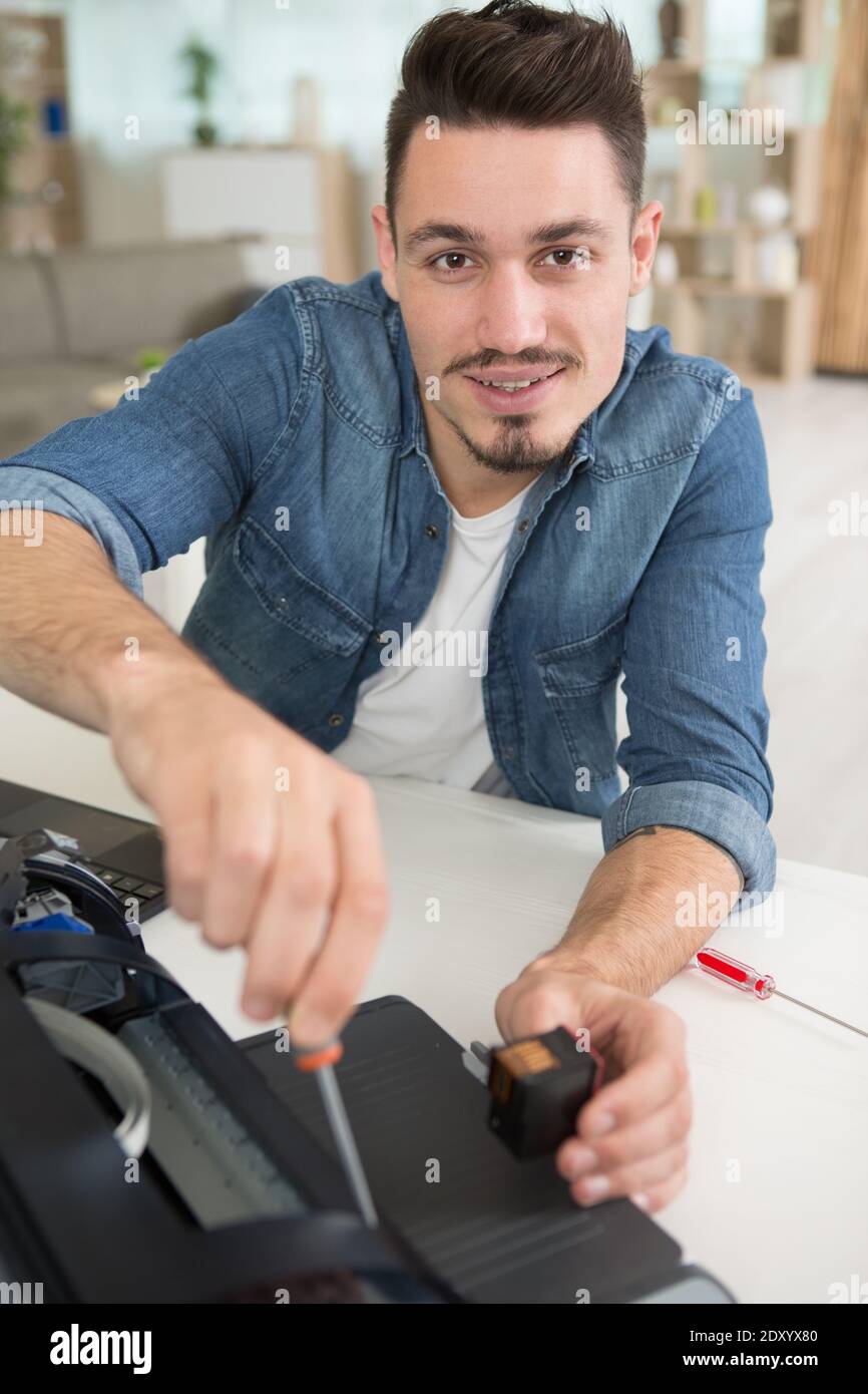 happy man fixing a printing machine Stock Photo - Alamy