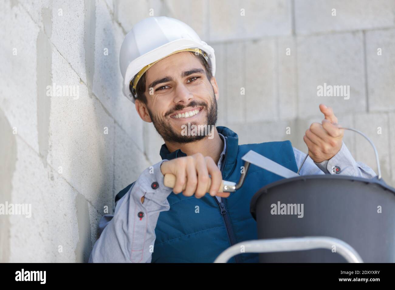 happy contractor employee applying plaster on wall Stock Photo - Alamy
