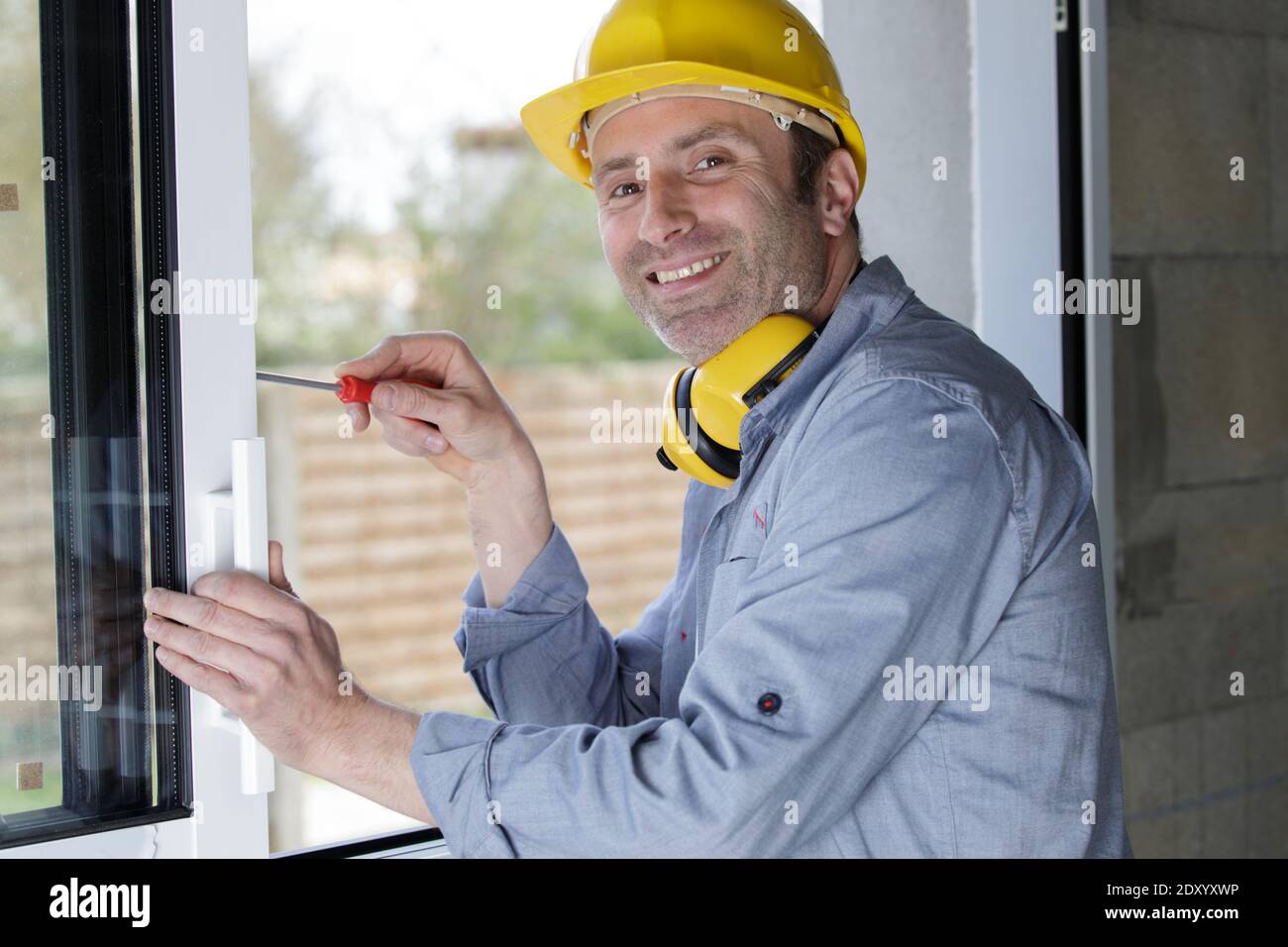 happy man drilling window frame Stock Photo - Alamy